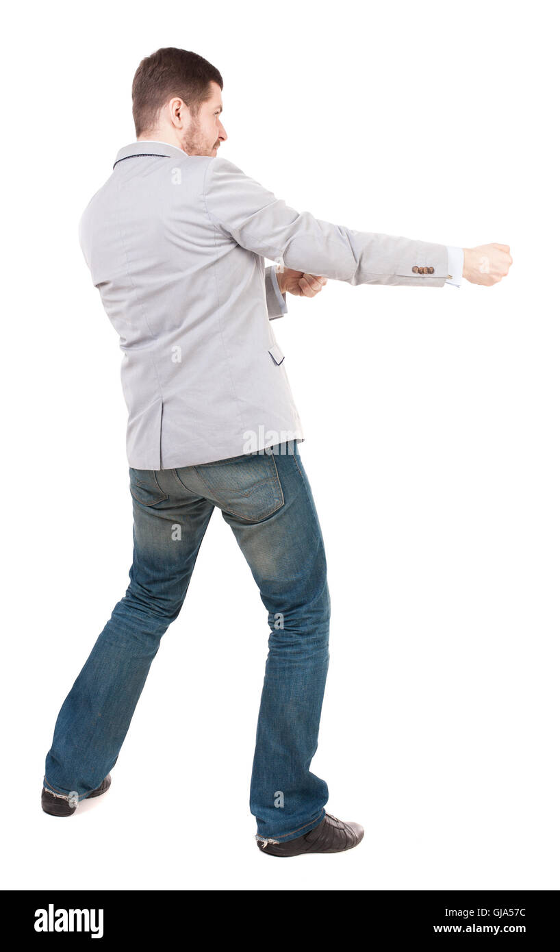 back view of standing man pulling a rope from the top or cling t Stock ...