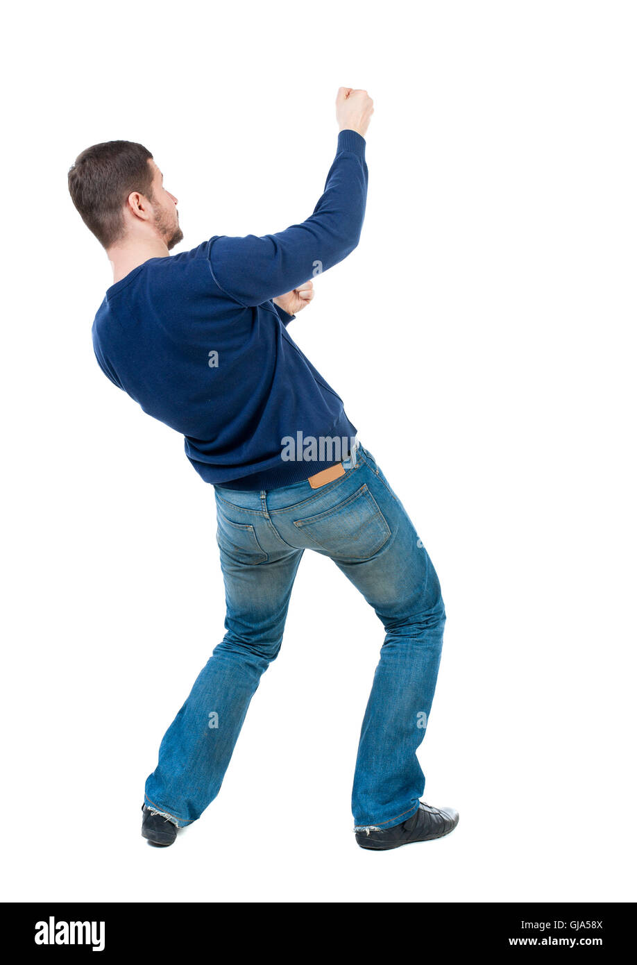 back view of standing man pulling a rope from the top or cling t Stock ...