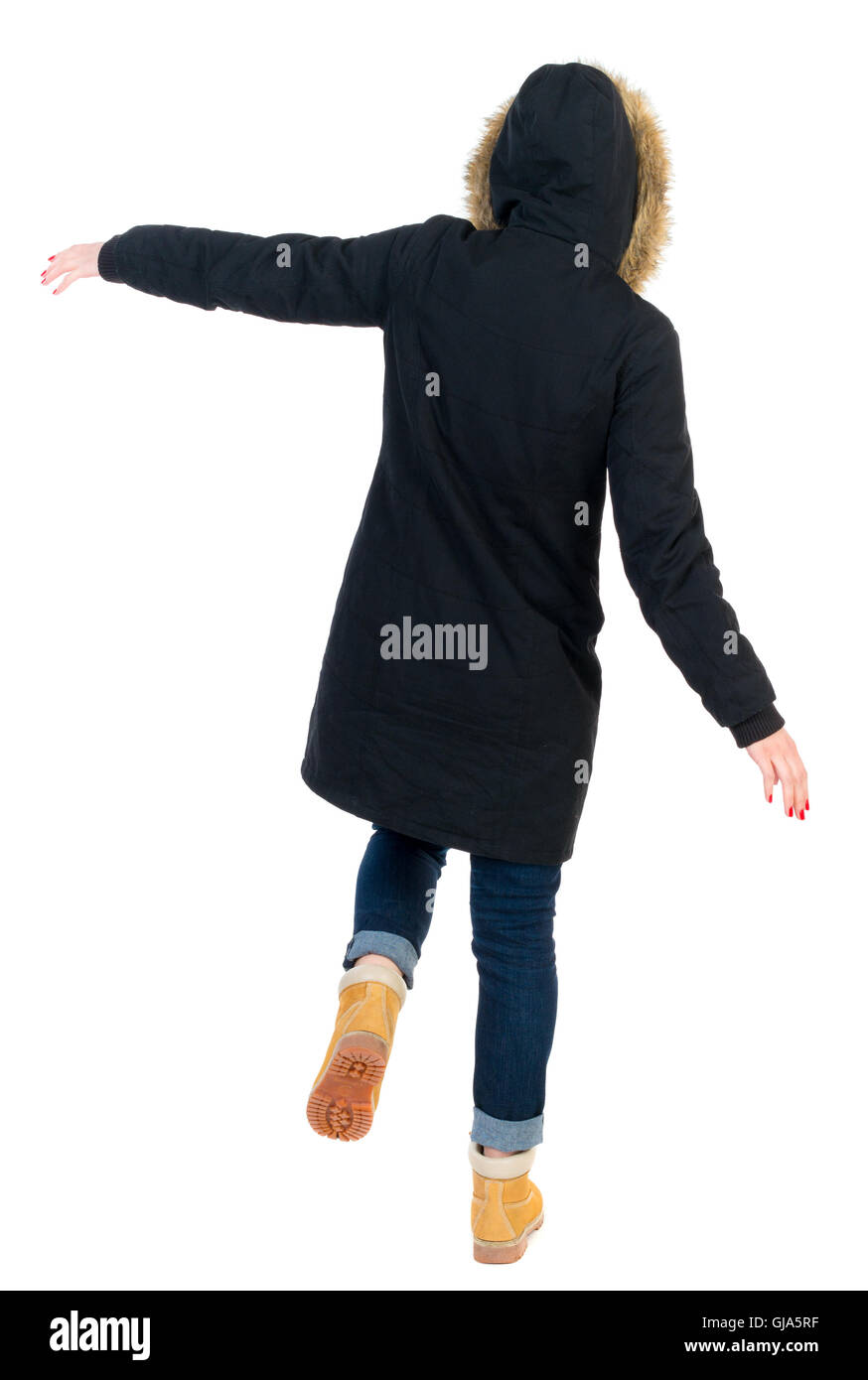 Back view woman in winter jacket Balances waving his arms Stock Photo ...