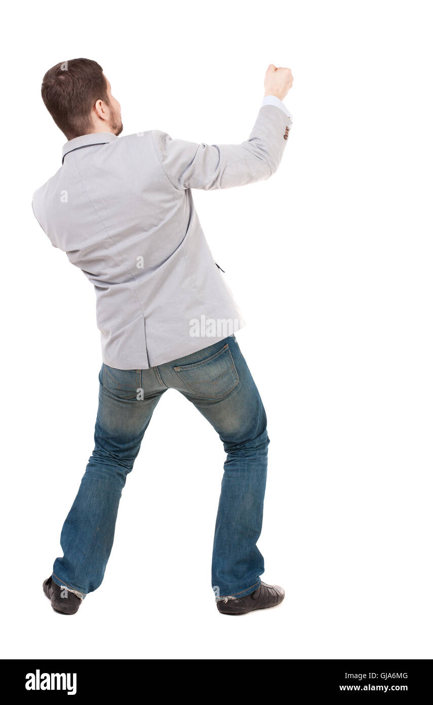 back view of standing man pulling a rope from the top or cling t Stock ...