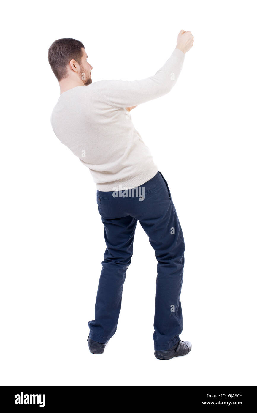 back view of standing man pulling a rope from the top or cling t Stock ...