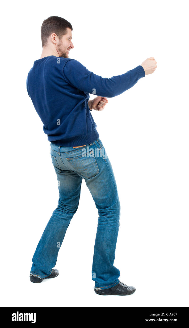 back view of standing man pulling a rope from the top or cling t Stock ...