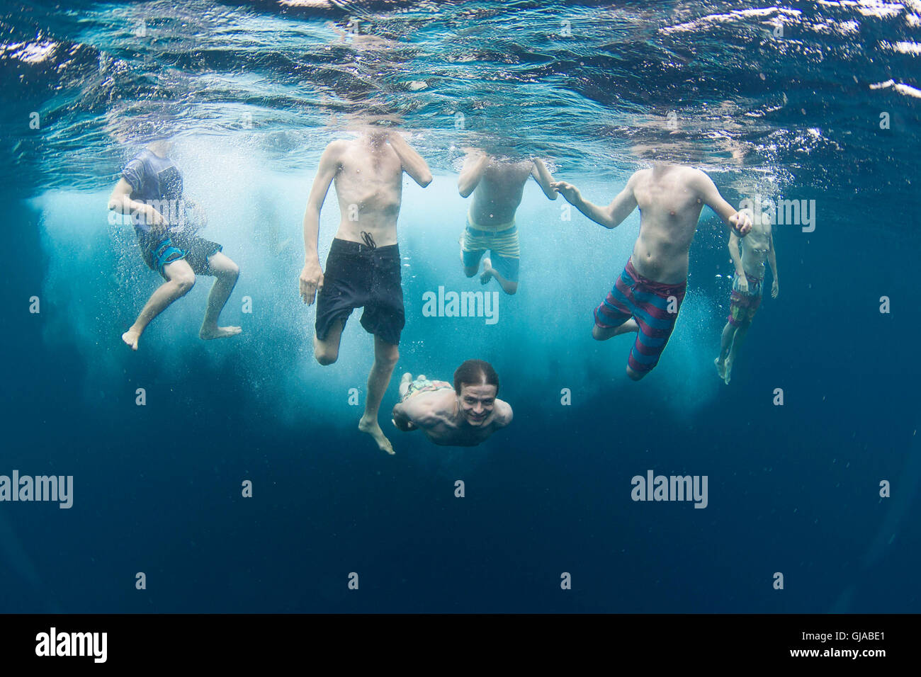 young man is diving under friends Stock Photo - Alamy