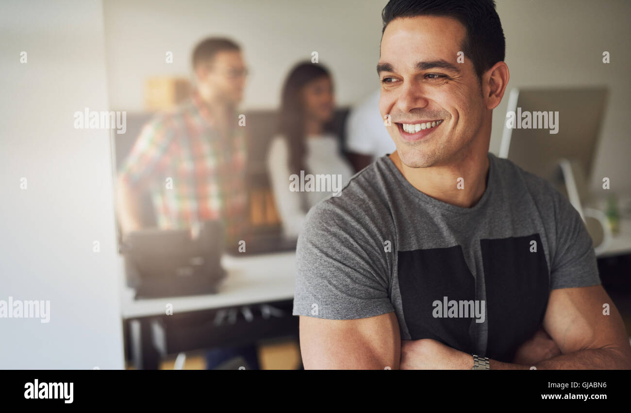Close up of smiling handsome male worker with folded muscular arms ...