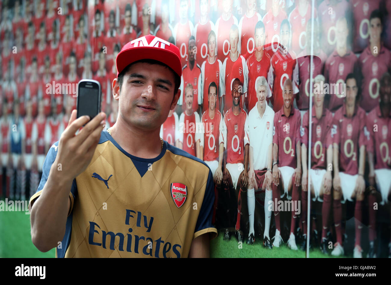 An Arsenal fan takes a selfie in front of a player wall before the ...