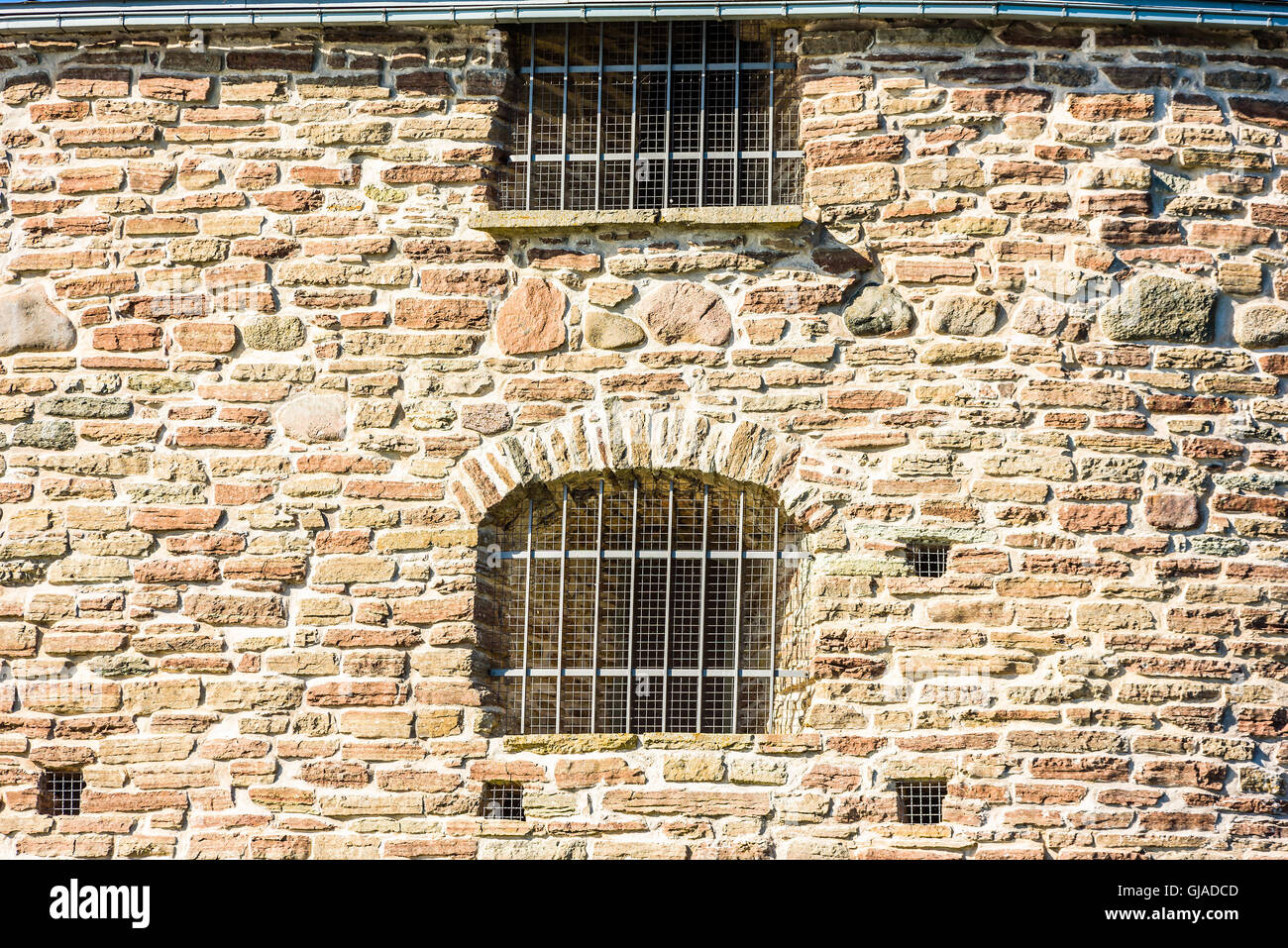 Barred prison windows on a castle or fortification Stock Photo - Alamy