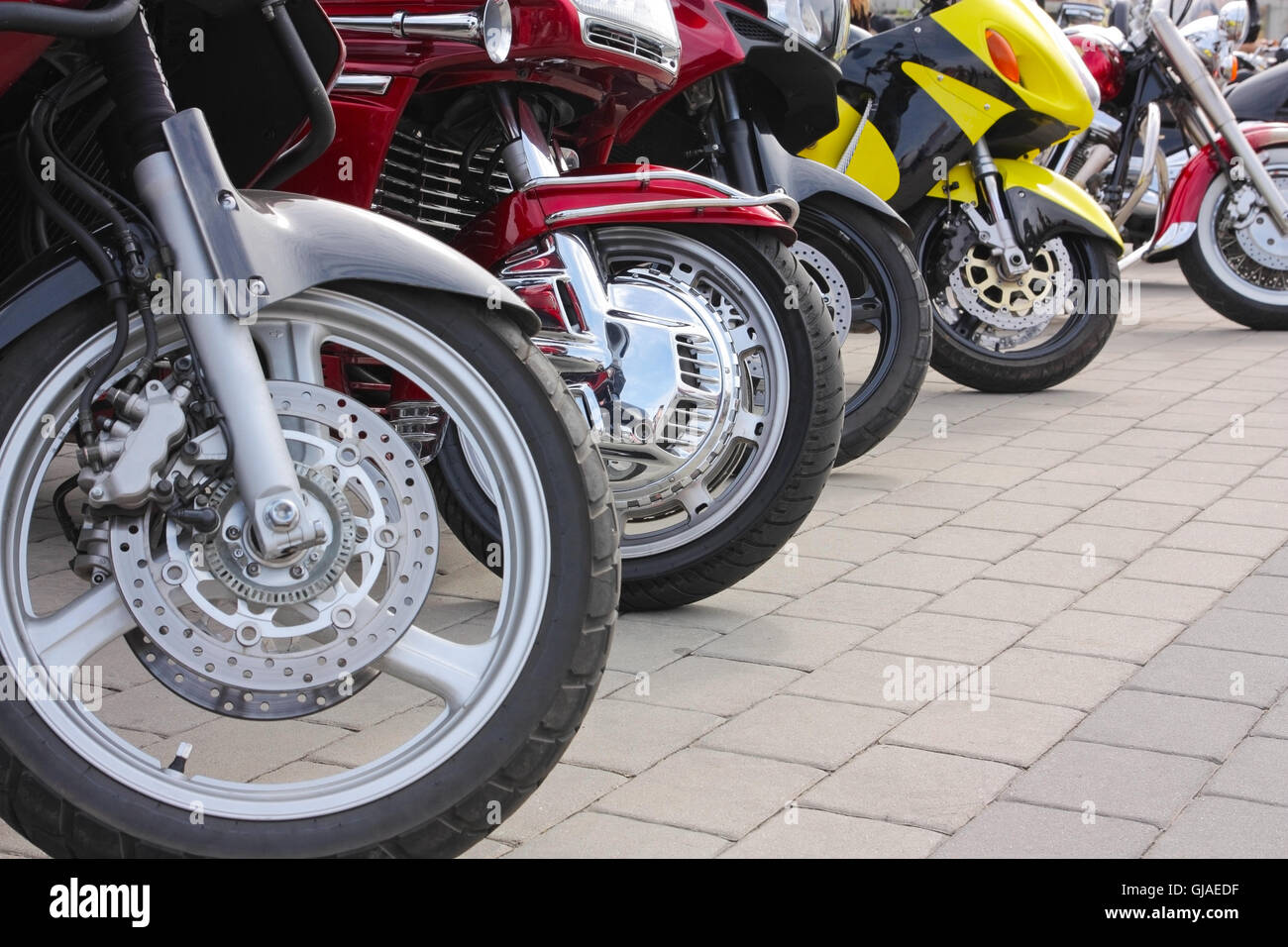 Motorcycles (motorbikes) stand in a row on the street on the sidewalk ...