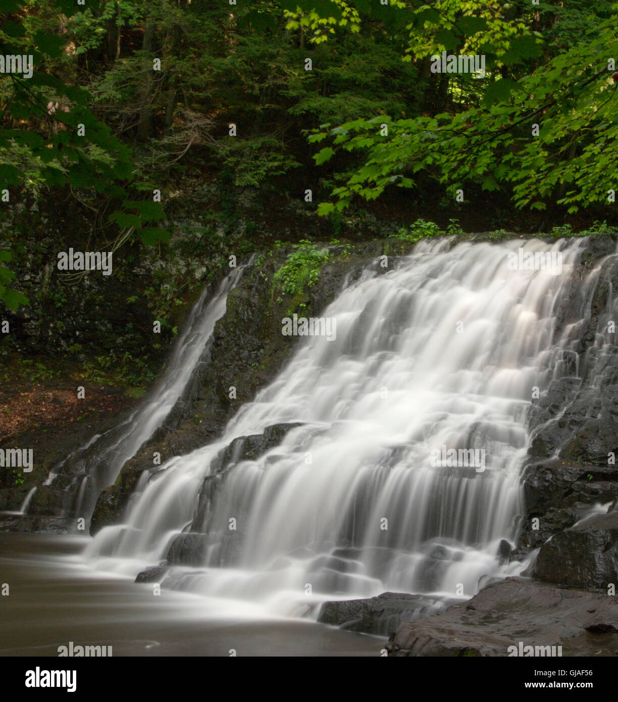 Waterfall flowing over rocky cliff Stock Photo - Alamy