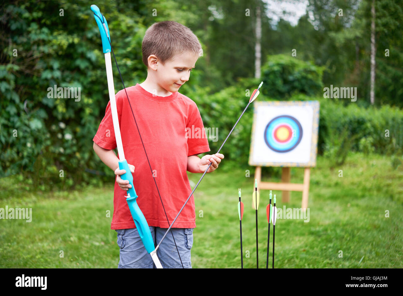 Little archer with bow and arrows outdoors Stock Photo - Alamy