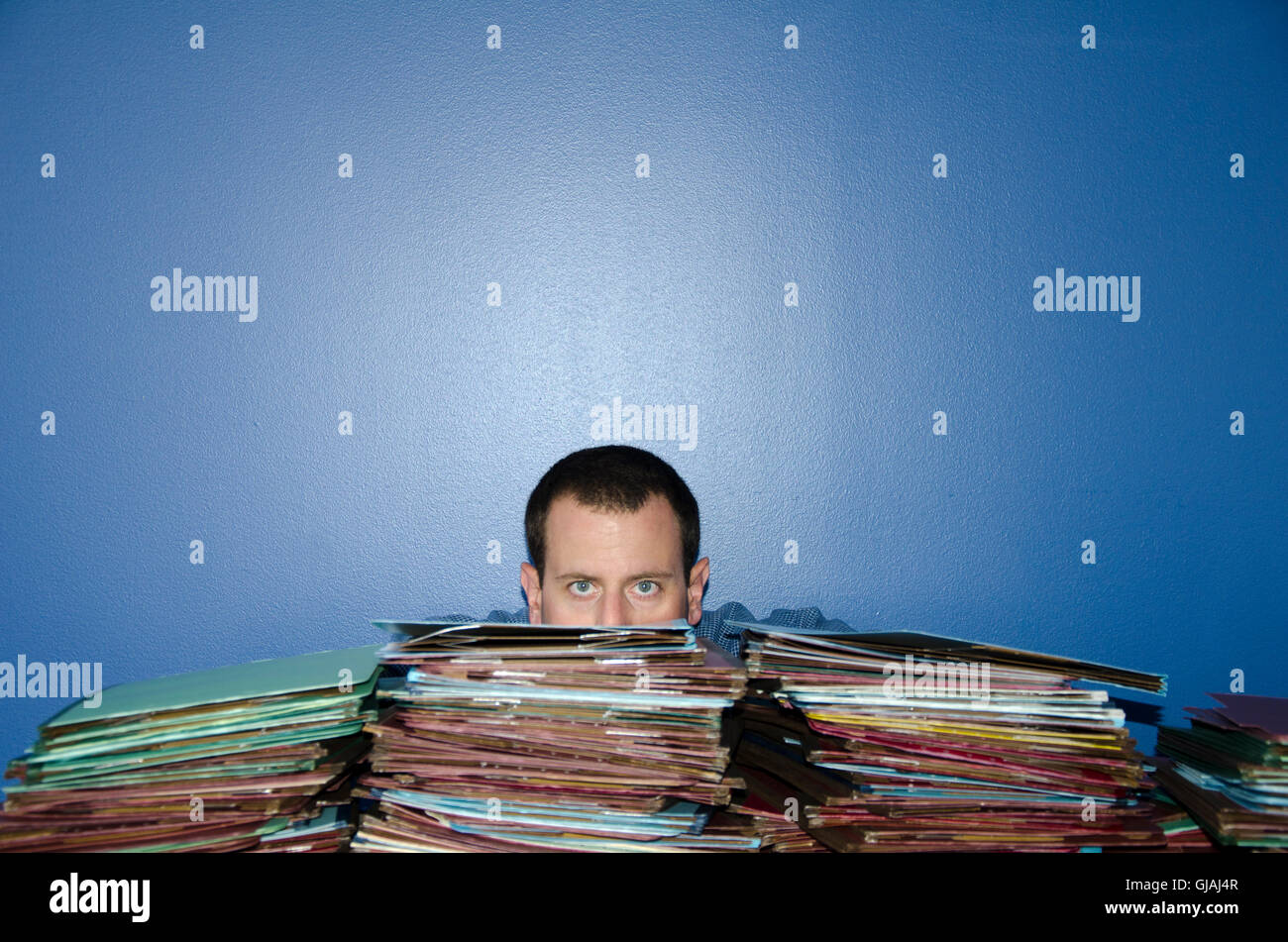 Man hiding behind piles hi-res stock photography and images - Alamy
