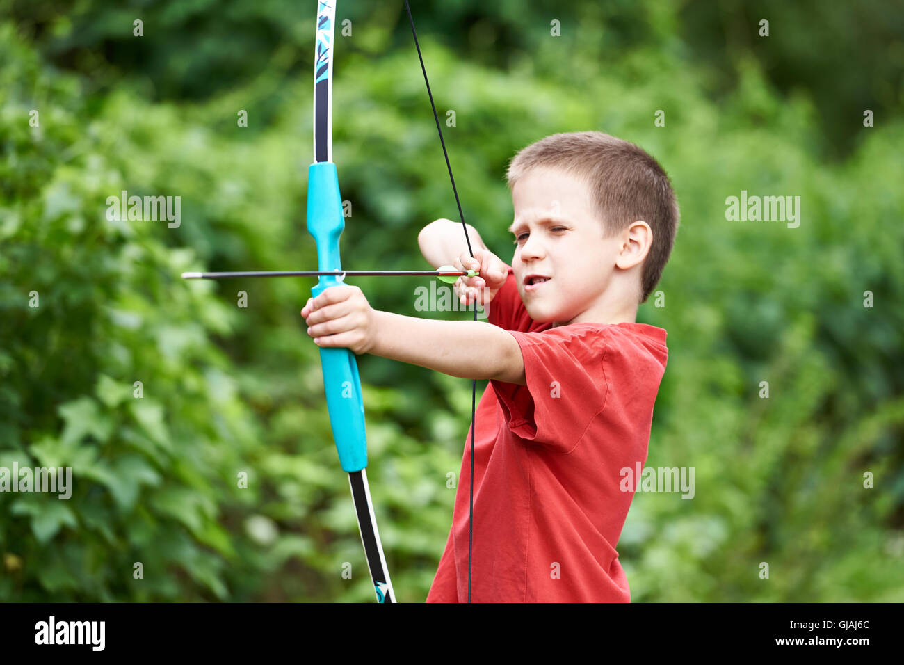 Little archer with bow and arrow outdoors Stock Photo - Alamy