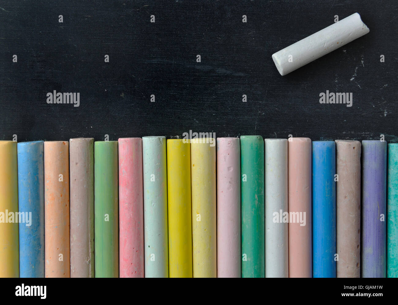 colorful chalks under a white chalk on a black board Stock Photo - Alamy