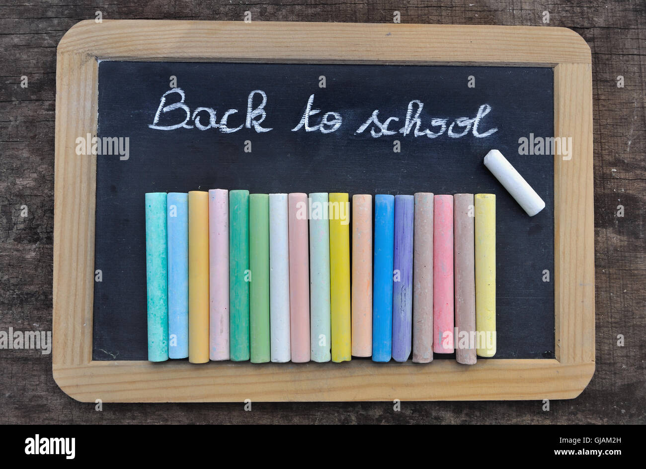 chalkboard with message "Back to school" with chalks on wooden ...