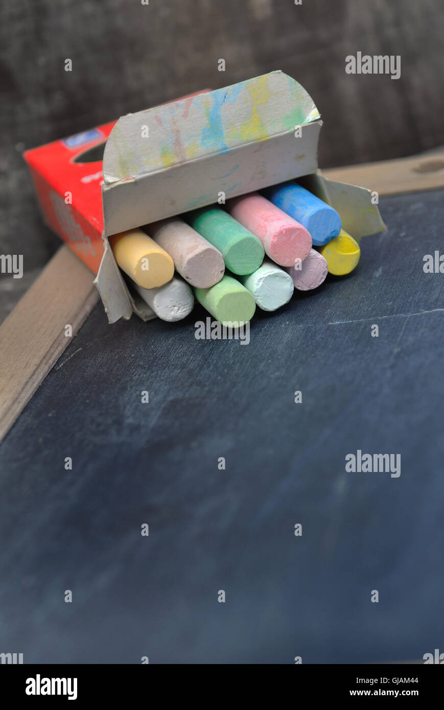 chalks in a box on a slate on wooden background Stock Photo - Alamy