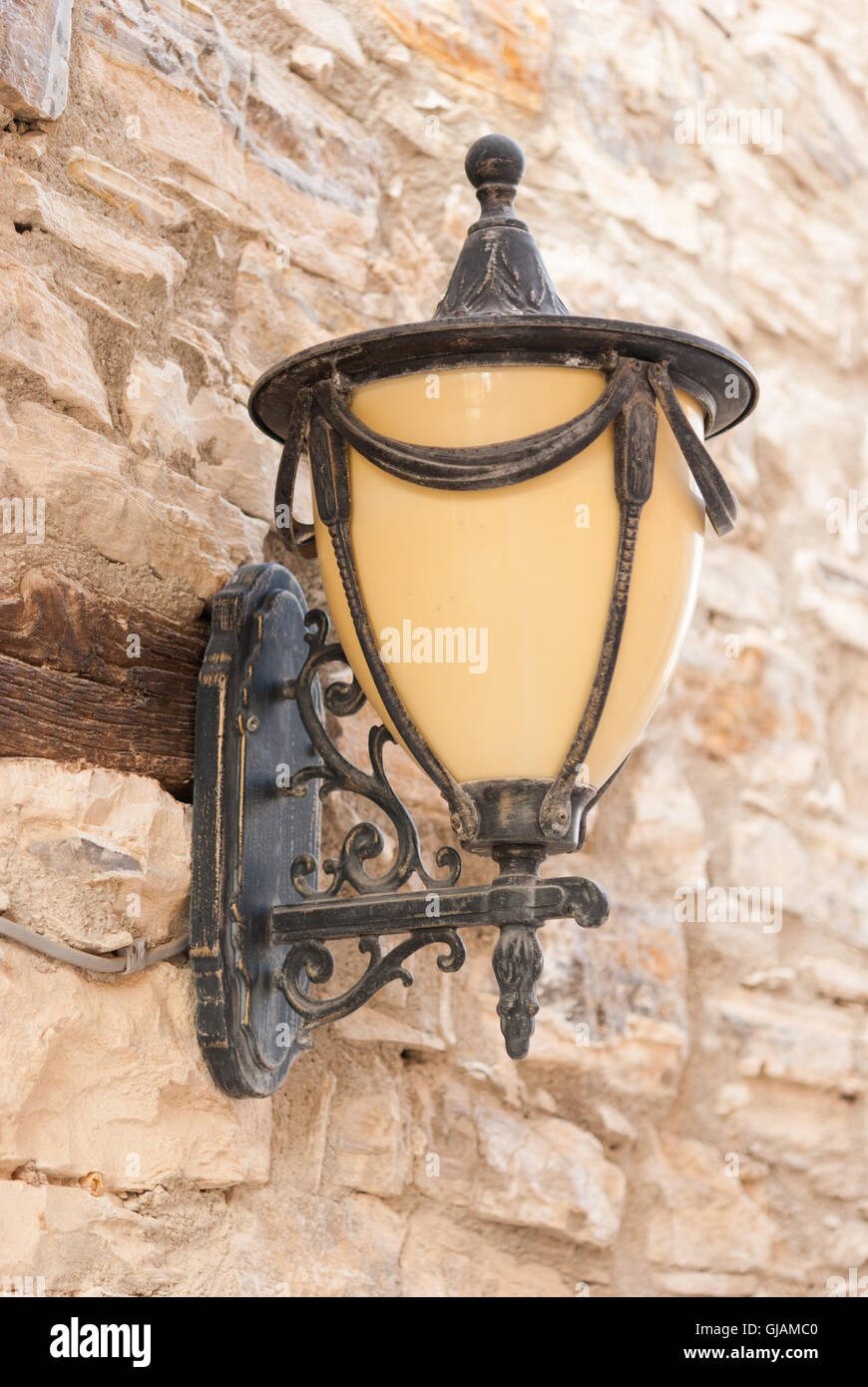 Old fashioned street light on the stone wall closeup Stock Photo - Alamy