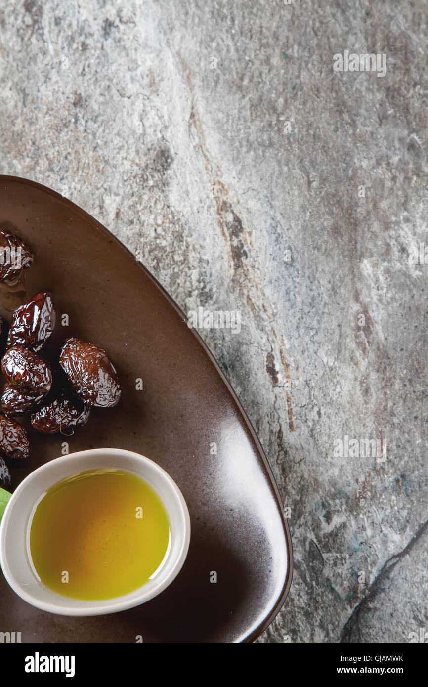 Green ripe olives and olive oil in a bowl. Dark background Stock Photo ...