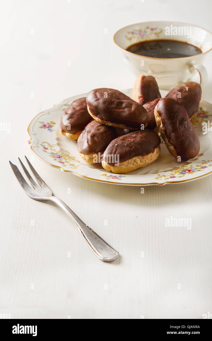 French Chocolate cake, eclairs with a cup of hot black coffee in a ...