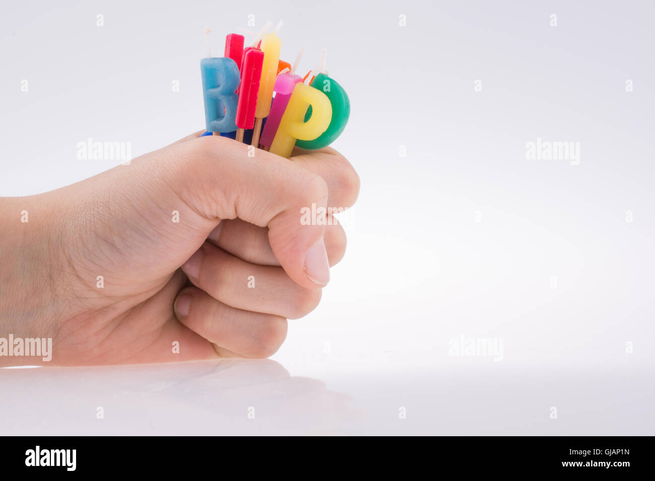 Hand holding letters made of candles on sticks Stock Photo - Alamy