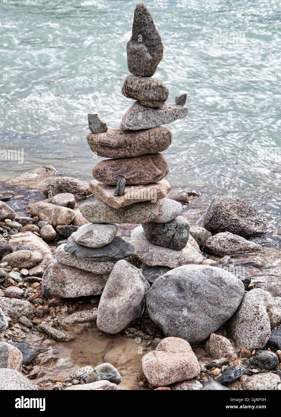 Stack of balanced rocks beside a flowing river Stock Photo - Alamy