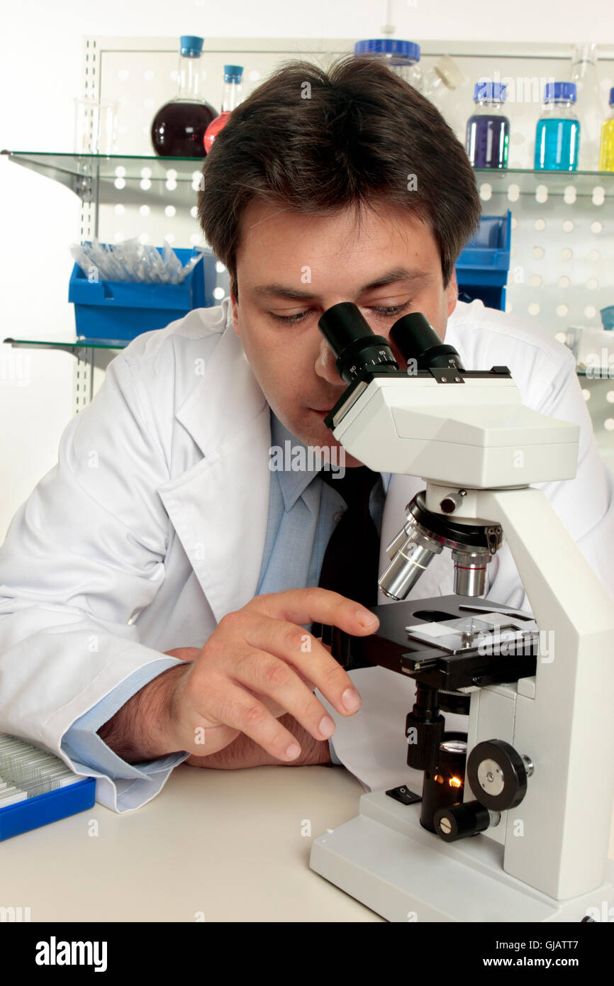 Scientist looking through microscope Stock Photo - Alamy