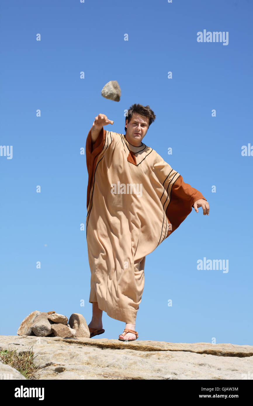 Ancient man casting a stone Stock Photo - Alamy