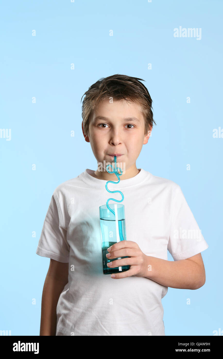 Thirsty boy sipping water from glass Stock Photo - Alamy
