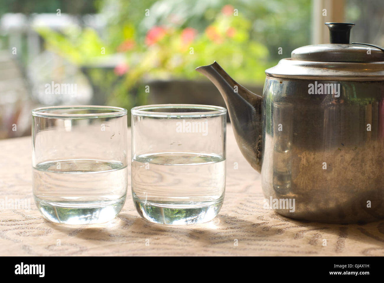 Two glass cups and steel teapot Stock Photo - Alamy