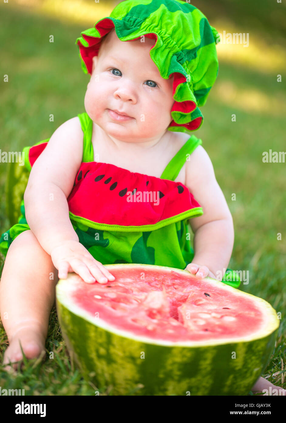 Little boy playing with watermelon sitting on the grass Stock Photo - Alamy