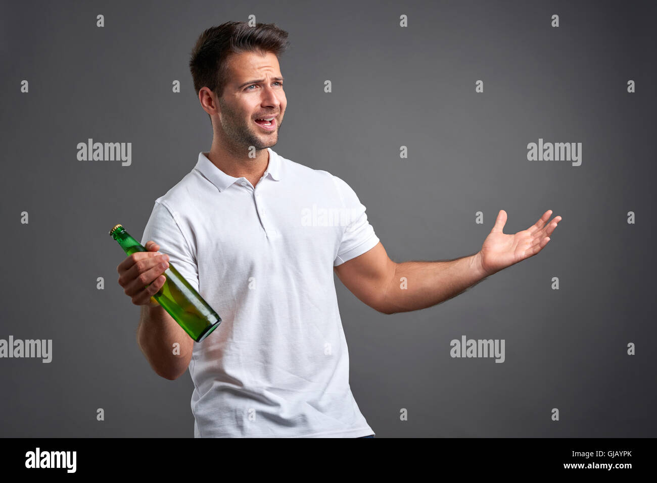 A handsome young man feeling disbelief and looking questioningly while ...