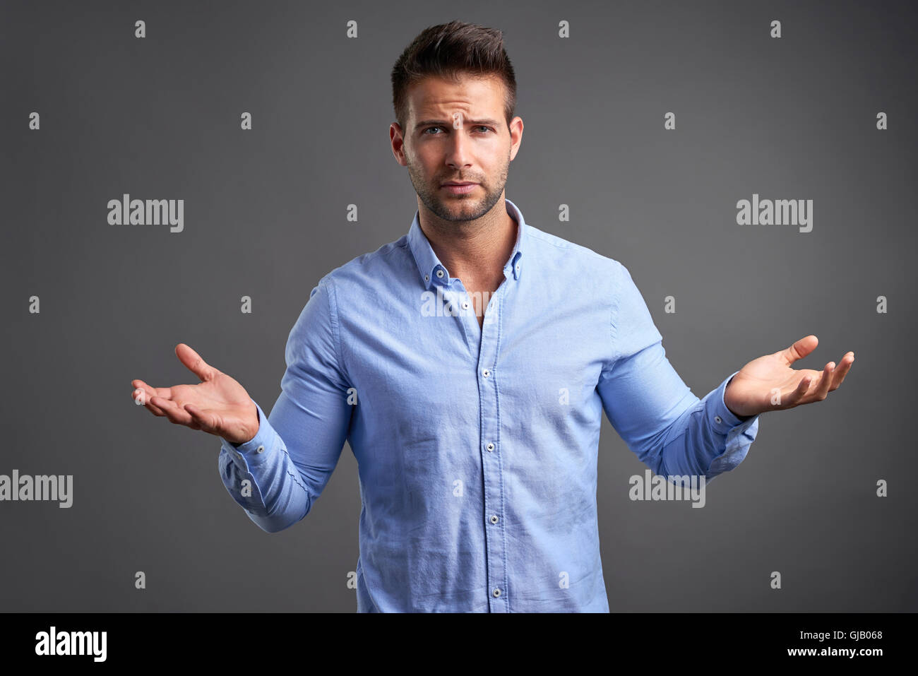 A handsome young man looking uncomprehendingly in to the camera in ...