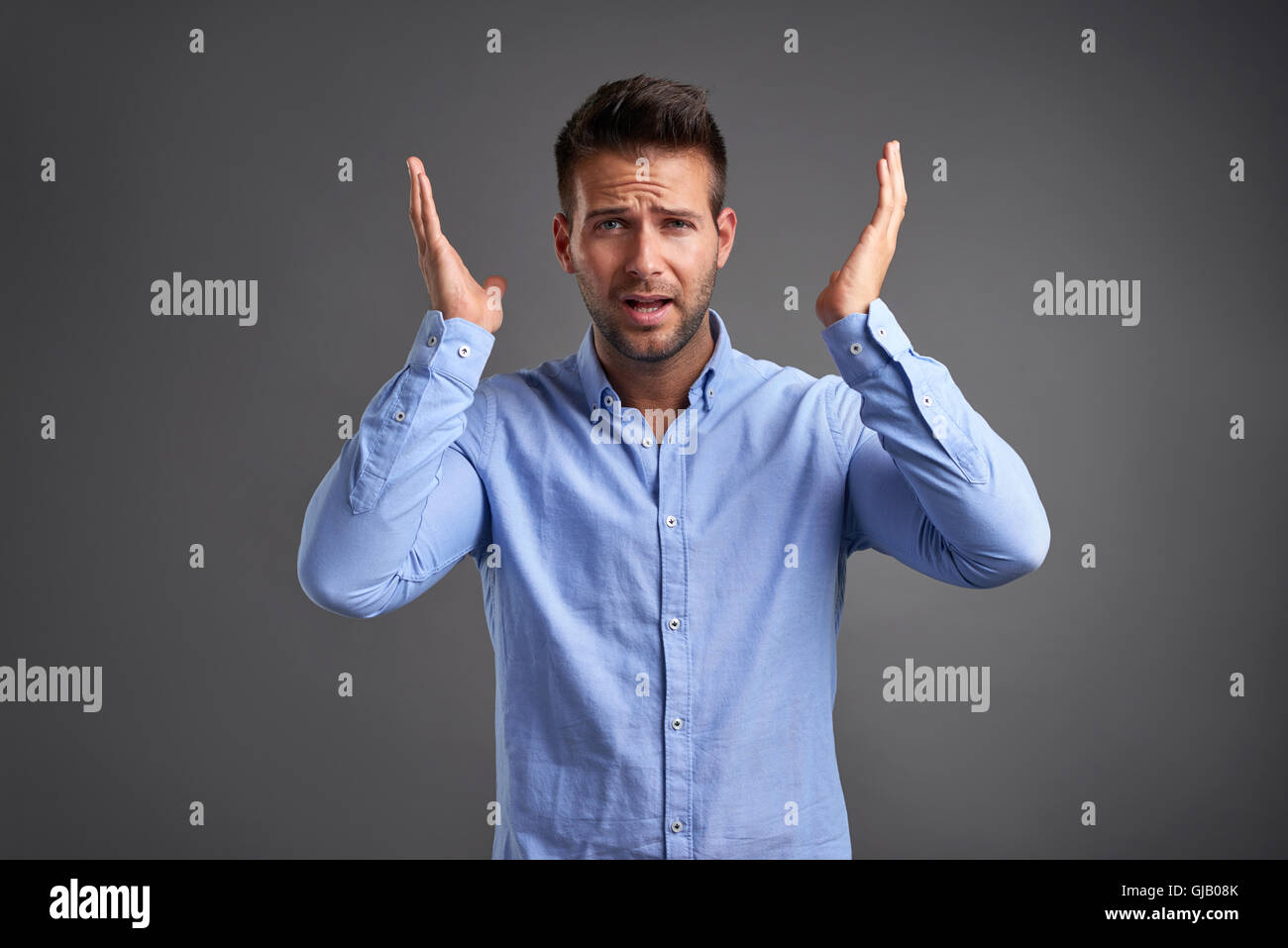 A handsome young man looking uncomprehendingly in to the camera in ...