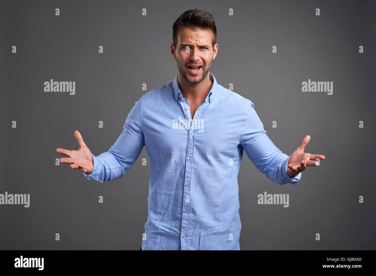 A handsome young man looking uncomprehendingly in to the camera in ...