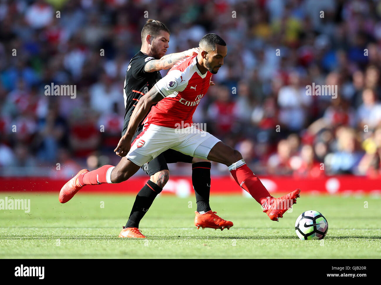 Arsenal's Theo Walcott and Liverpool's Alberto Moreno battle for the ...