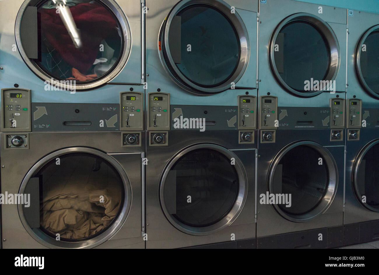 Washing clothes and drying at the Laundromat with chrome washer and ...