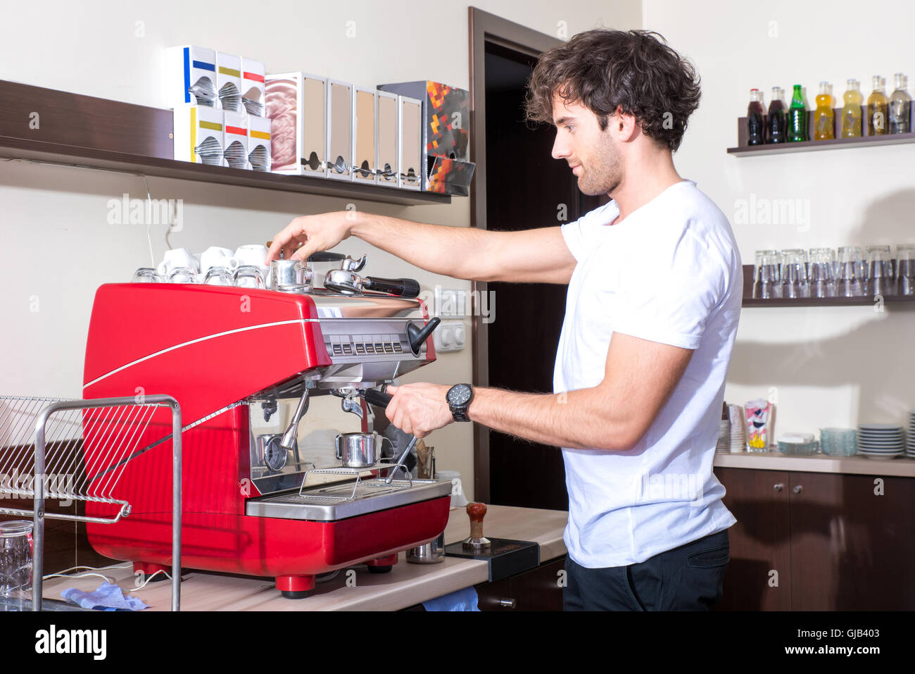 A handsome young man making coffee at the bar in a coffee shop Stock ...