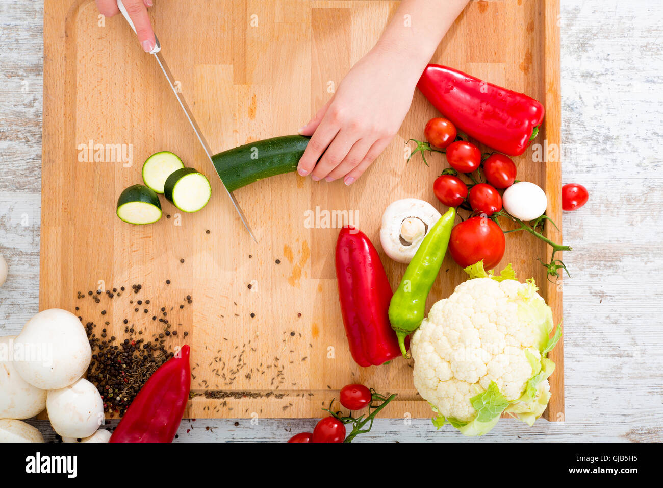 A woman chopping up vegetables at a table Stock Photo - Alamy