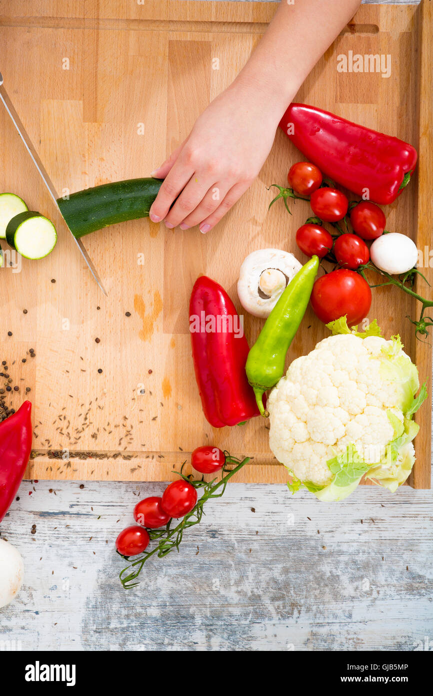 A woman chopping up vegetables at a table Stock Photo - Alamy
