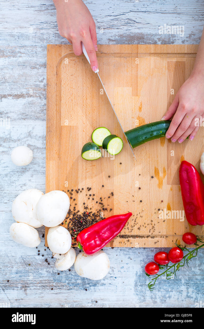 A woman chopping up vegetables at a table Stock Photo - Alamy