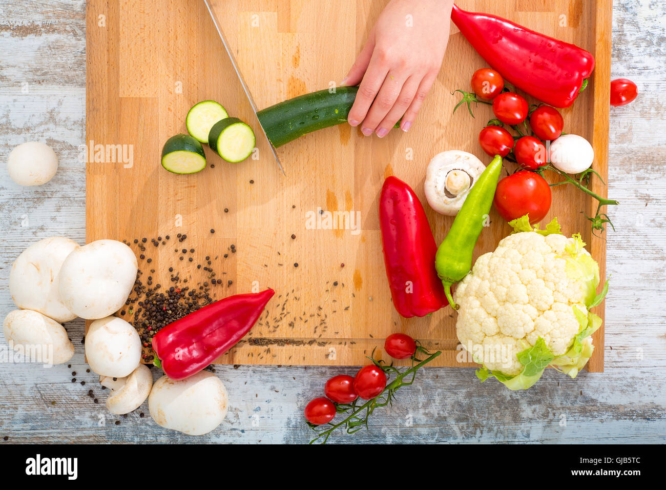 A woman chopping up vegetables at a table Stock Photo - Alamy