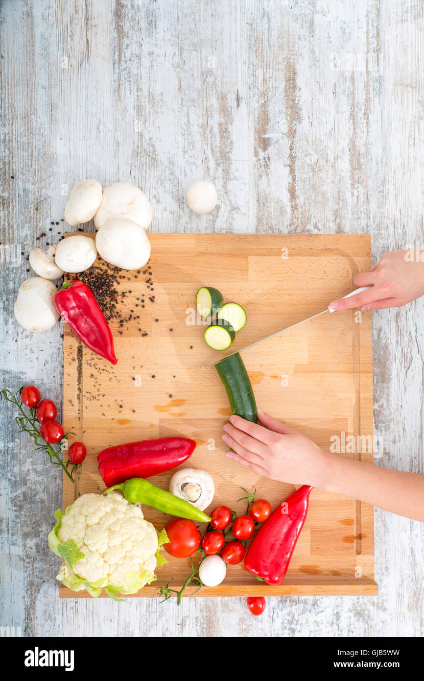 A woman chopping up vegetables at a table Stock Photo - Alamy
