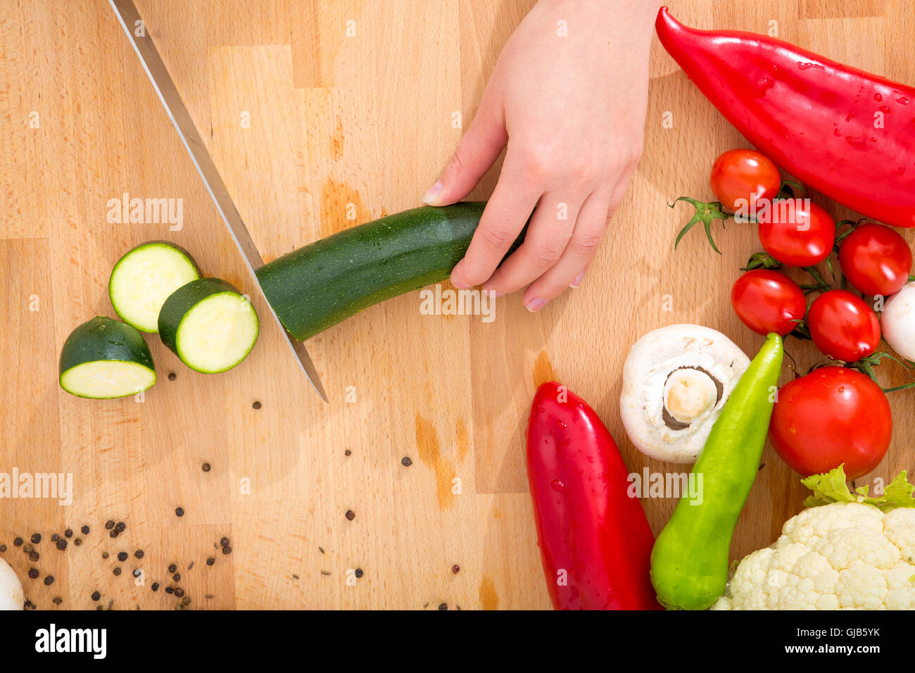 A woman chopping up vegetables at a table Stock Photo - Alamy