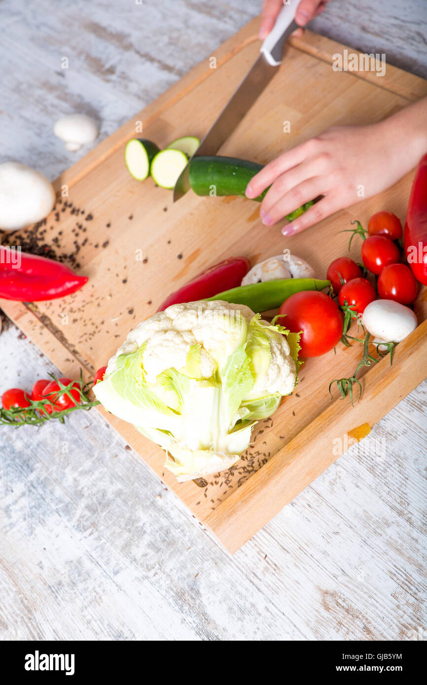 A woman chopping up vegetables at a table Stock Photo - Alamy
