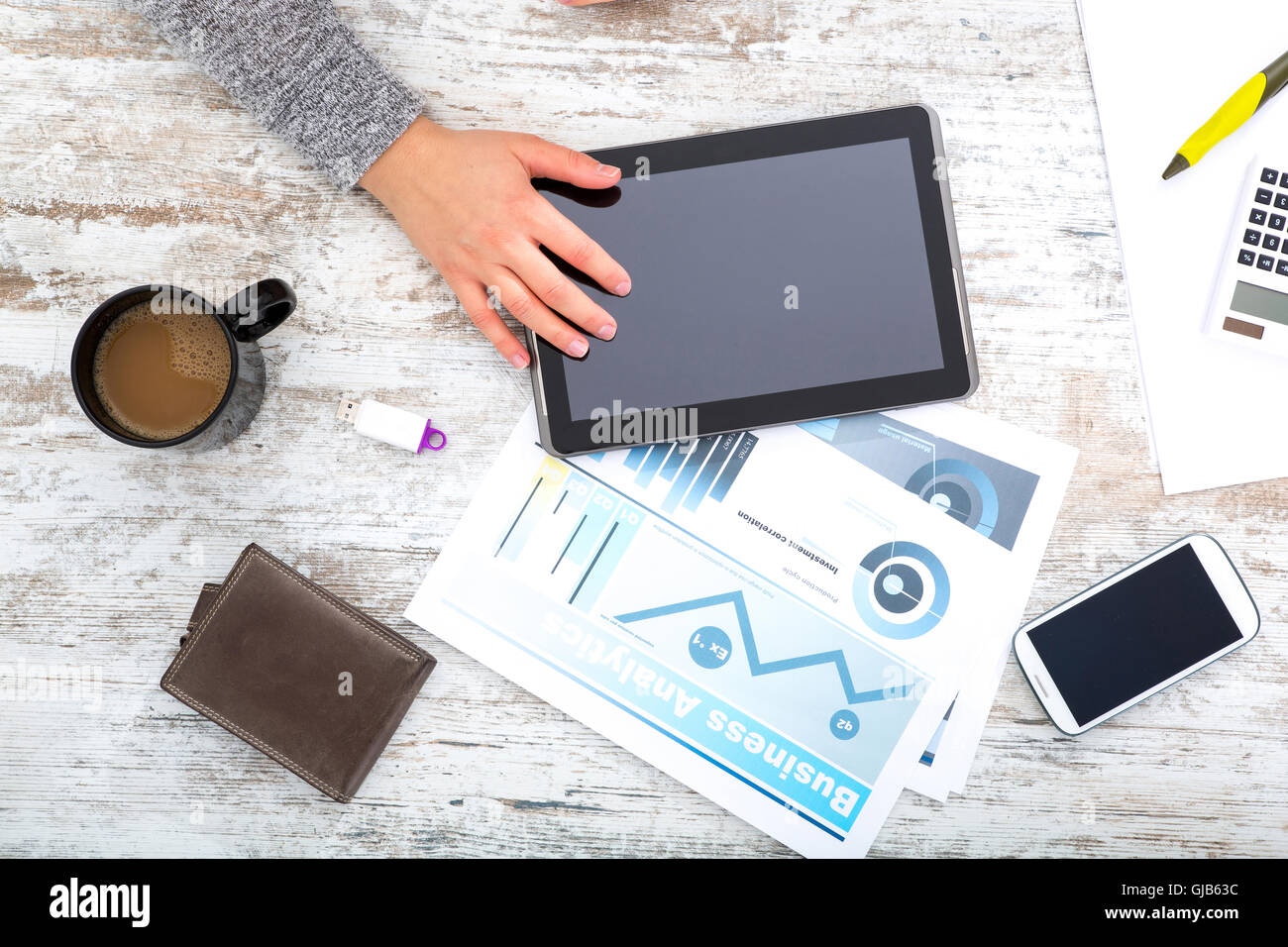 A woman’s hand at a table useing a tablet Stock Photo - Alamy