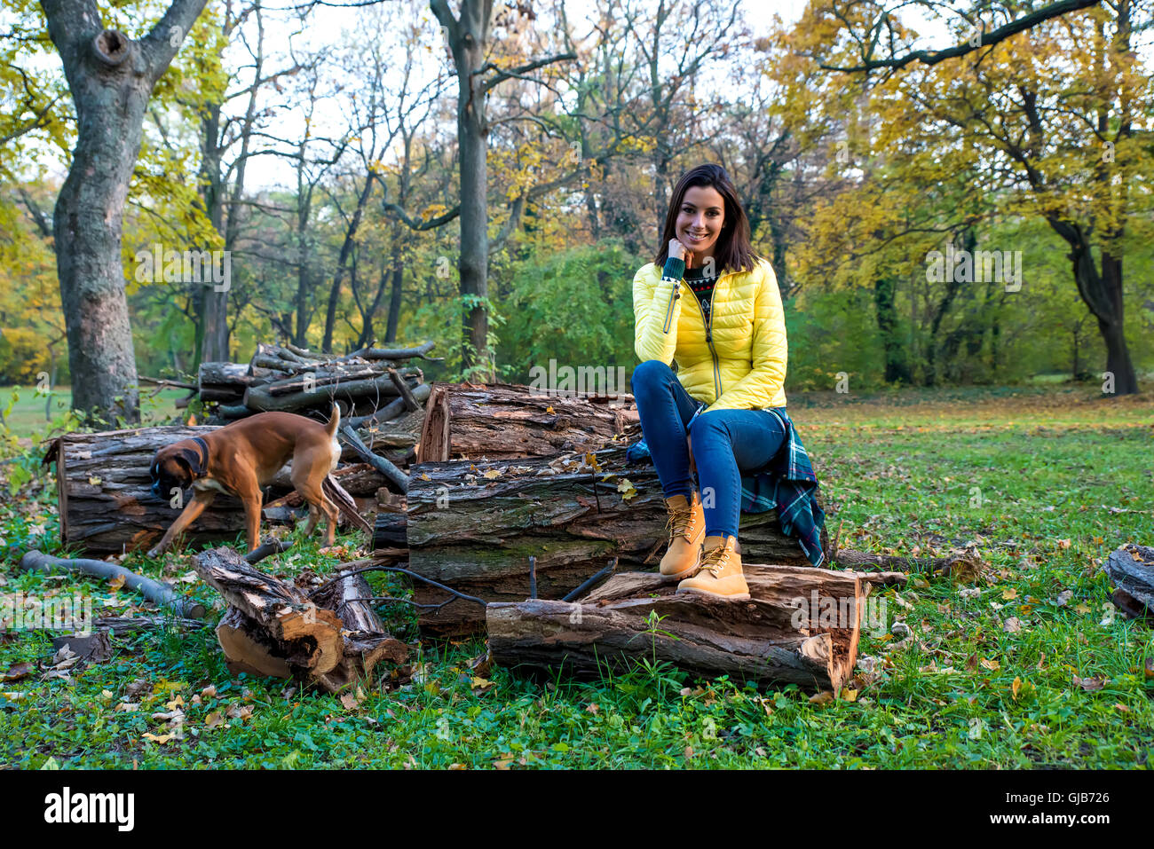 Beautiful young woman enjoying the autumn in the forest with her dog ...