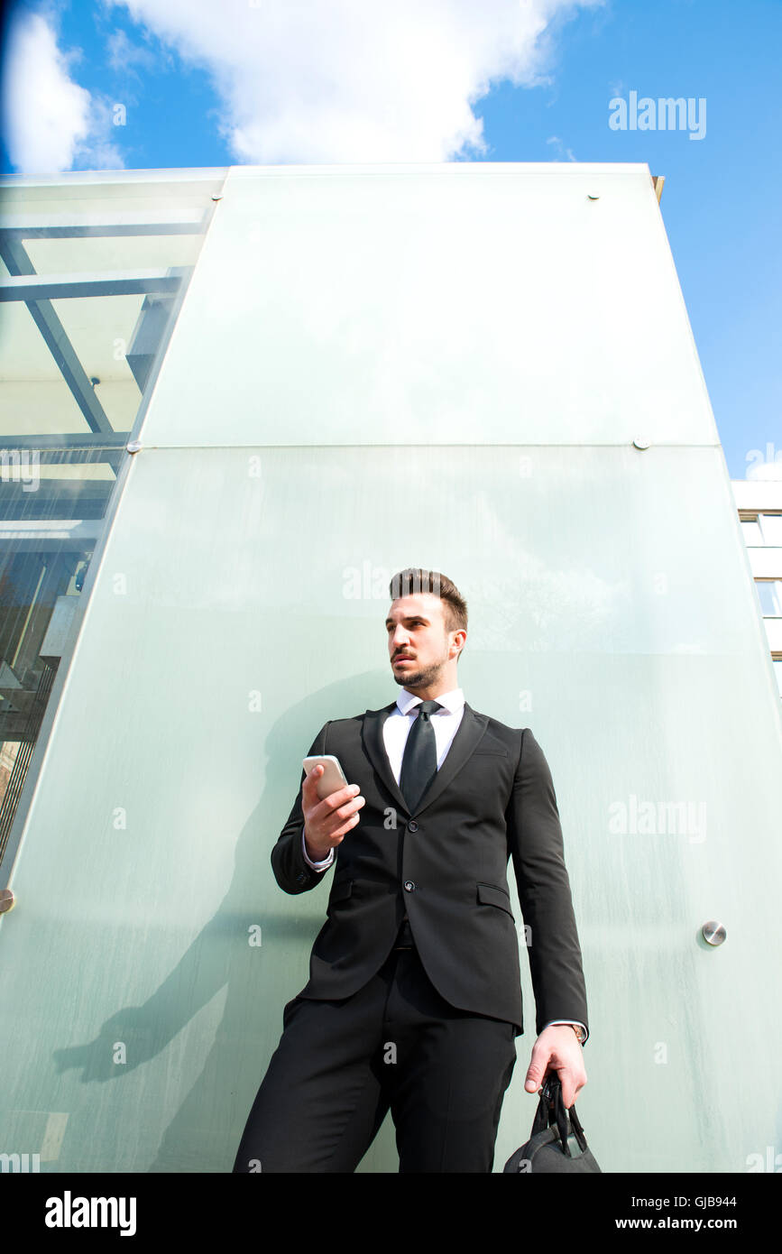A business man standing in front of a modern office building Stock ...