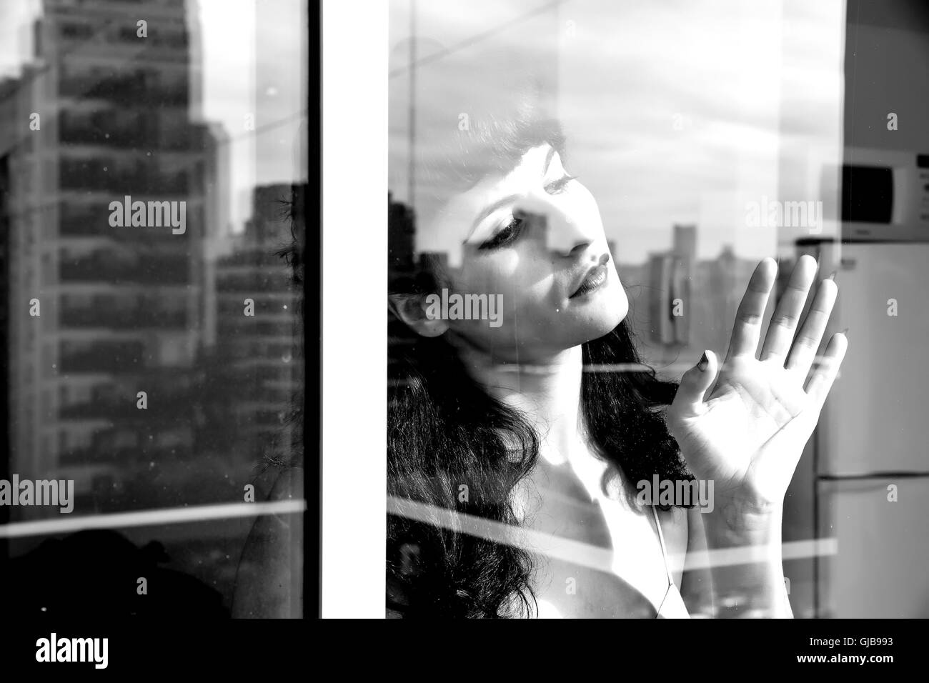 A pensive vintage girl standing behind a window Stock Photo - Alamy