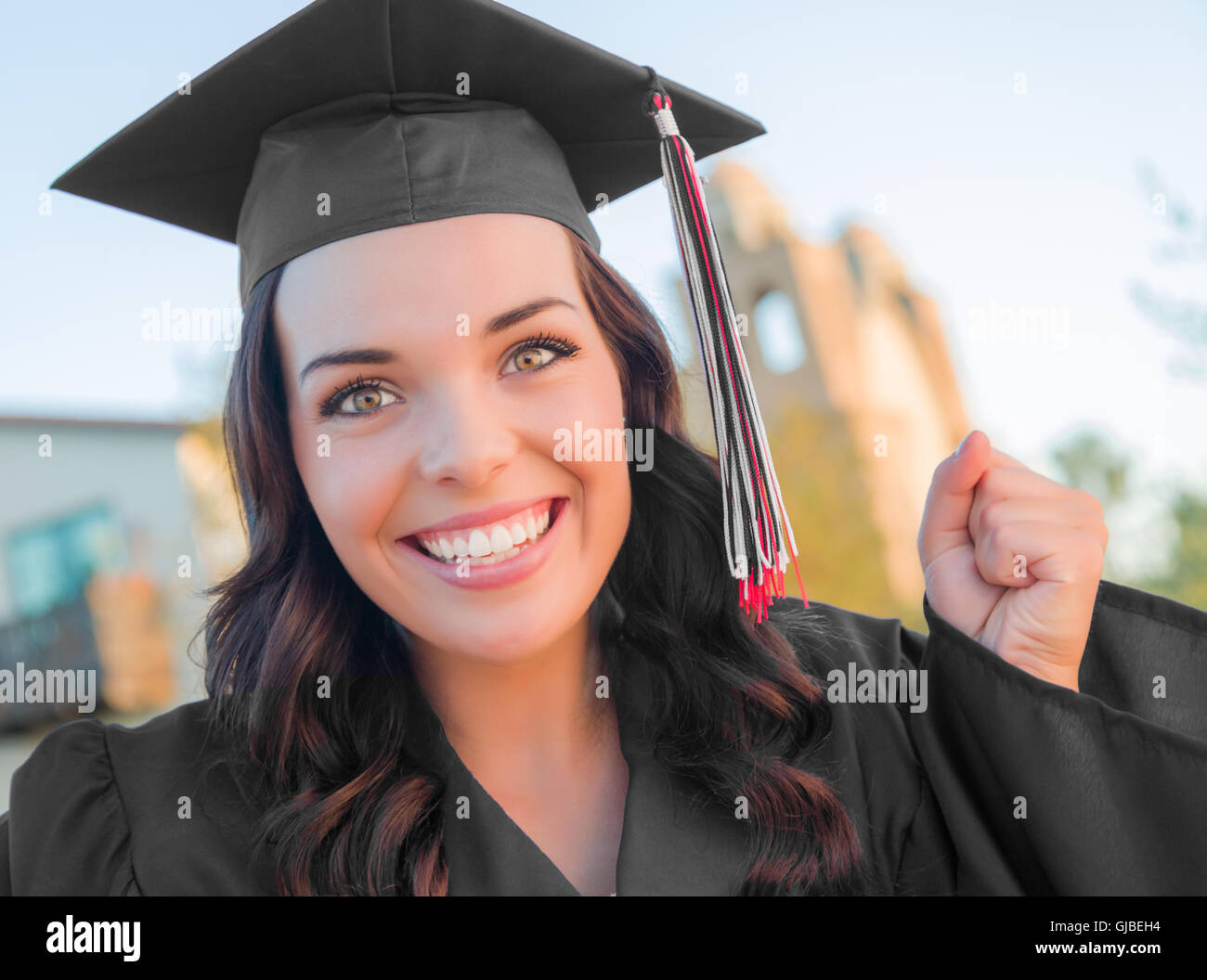 Happy Graduating Mixed Race Woman In Black Cap and Gown Celebrating on ...