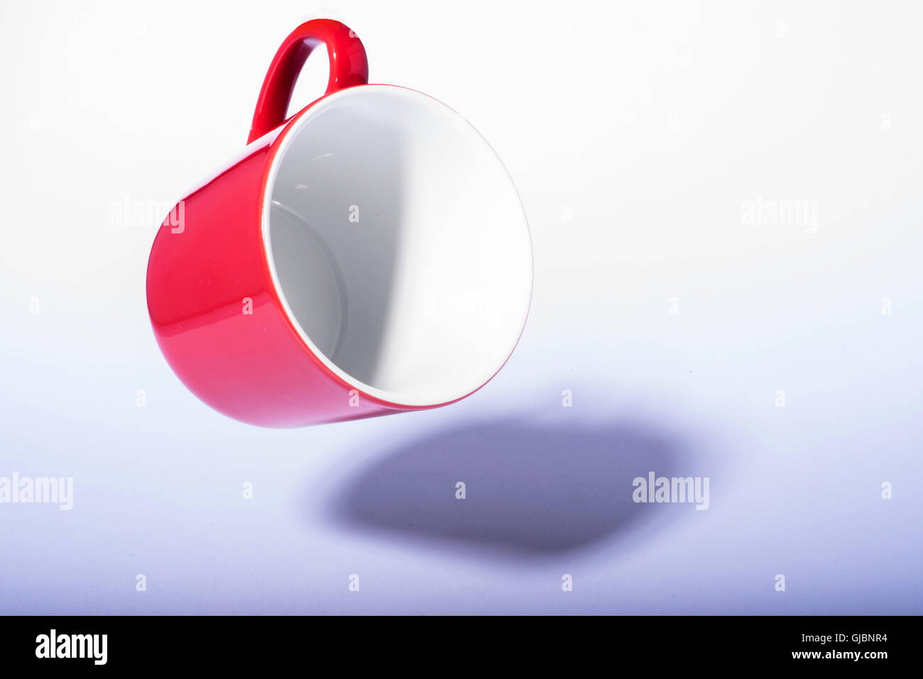 red coffee cup flying over white background with shadow Stock Photo - Alamy