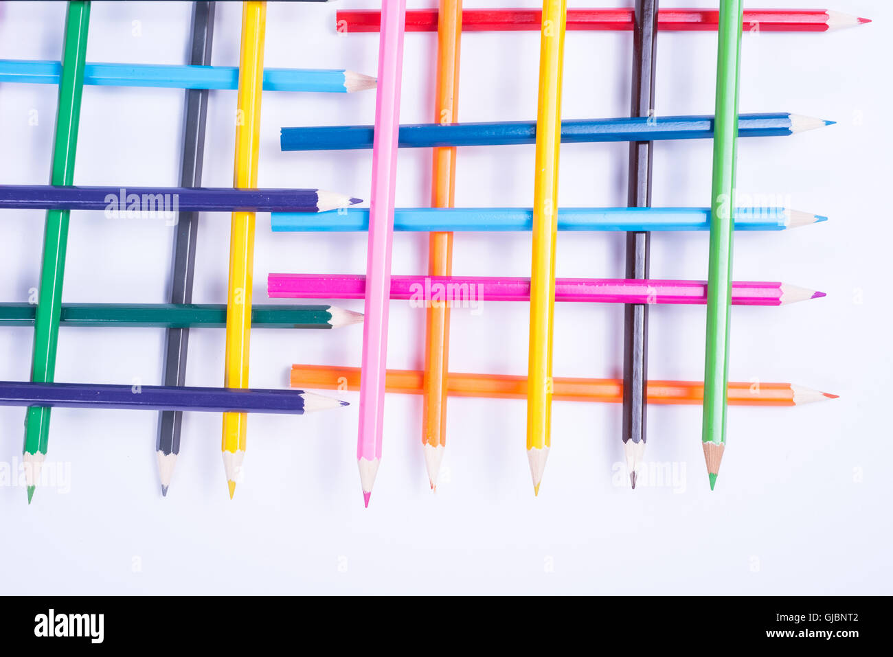 colorful pencils organized in a geometric form on white background ...