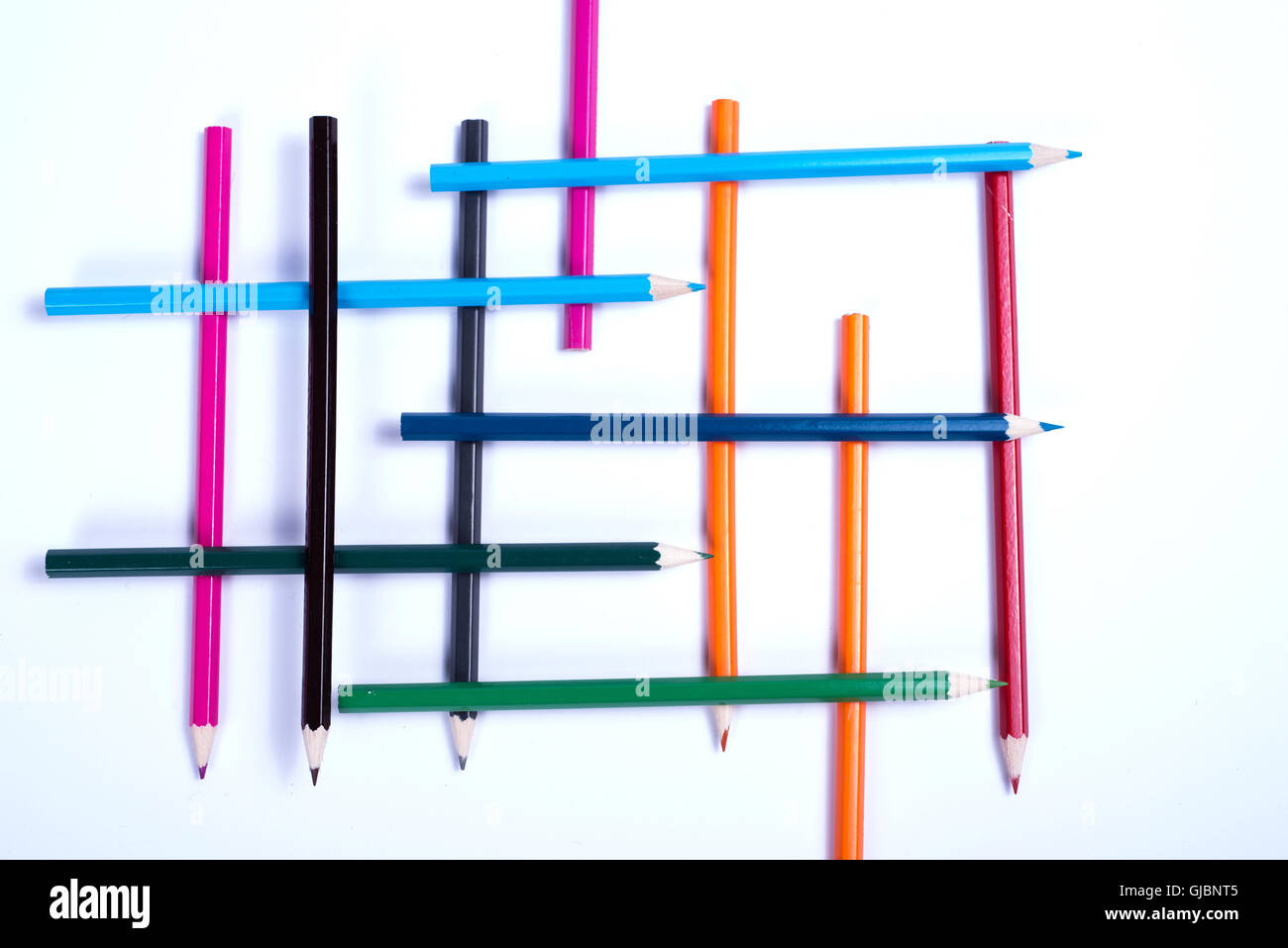 colorful pencils organized in a geometric form on white background ...